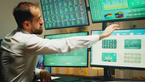 Male stock market trader working from home office and running numbers ...