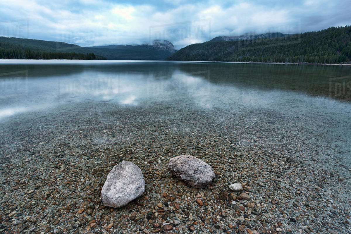 Two boulders in the shallow Redfish Lake with the Sawtooth Mountains of ...