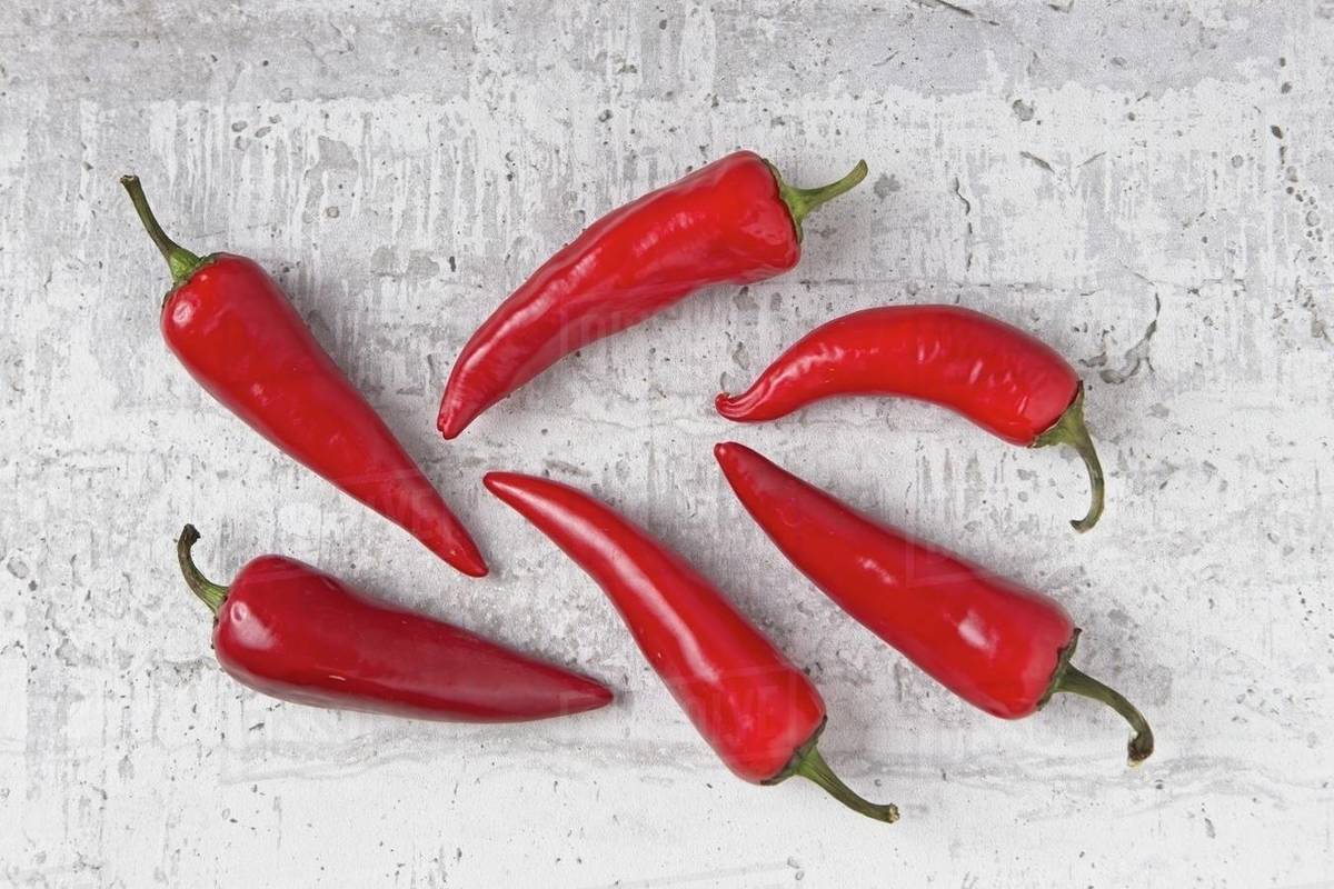 An overview photo of spicy whole red peppers layed out in a display on ...