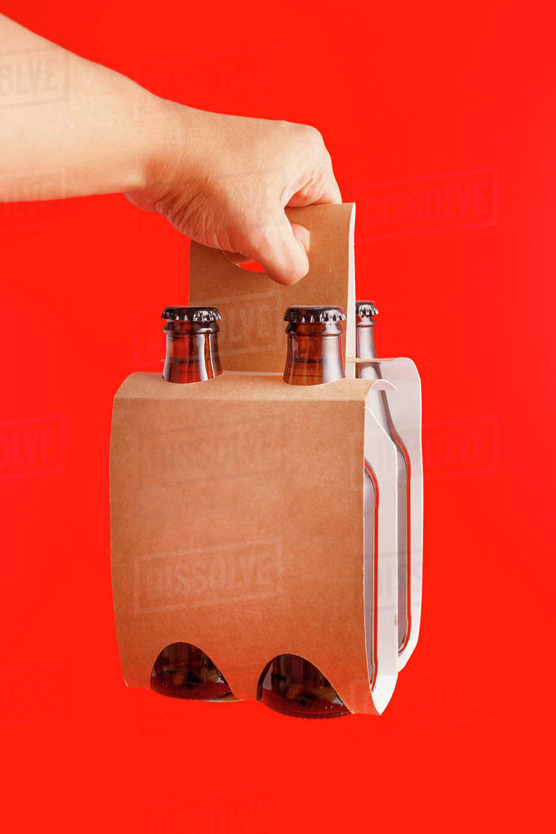 Hand holding a four-pack beer - Royalty-free Stock Photo | Dissolve