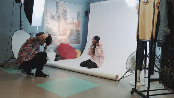 Backstage of the photo shoot: black model sitting on the floor and ...