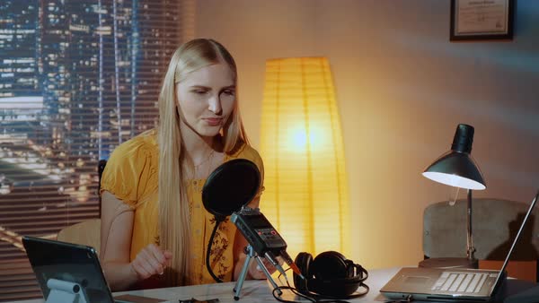 Close-up of female poet reading her poem into the microphone in home ...