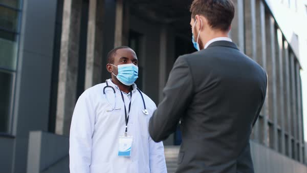 Interview of serious multiracial doctor wearing protective mask at ...