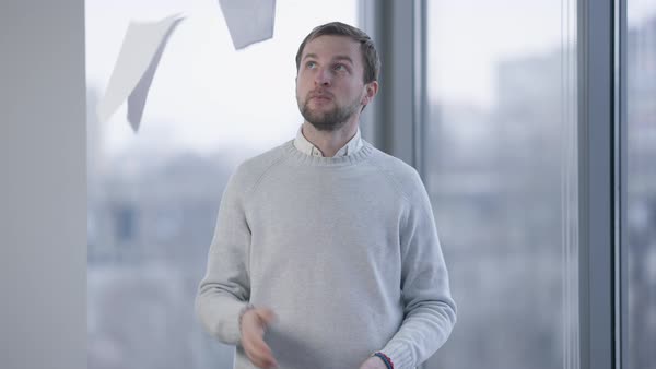 Sad man tearing paper and looking out the window in office. - Stock ...