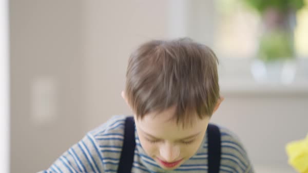 Front view smiling autistic curios boy painting with unrecognizable ...