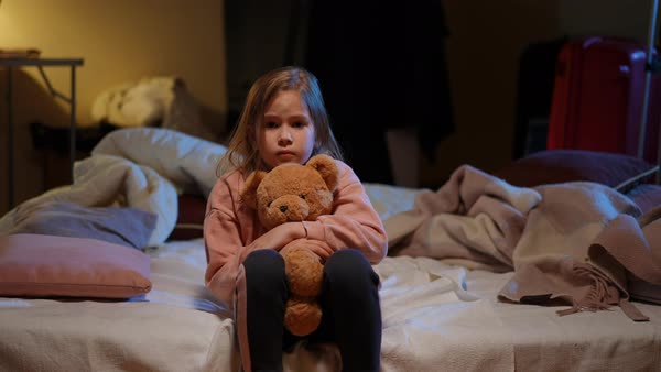Portrait of stressed scared Ukrainian girl hugging teddy bear looking ...