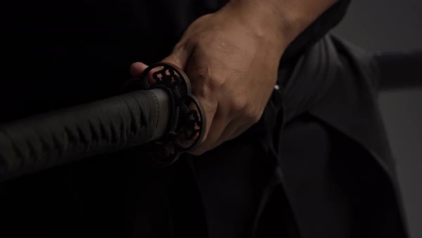 Japanese man, samurai, holds in his hand his sword, a katana in a ...