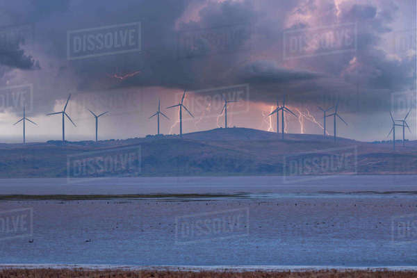 Photograph of large Wind Turbines in a row along a hill ridge line ...