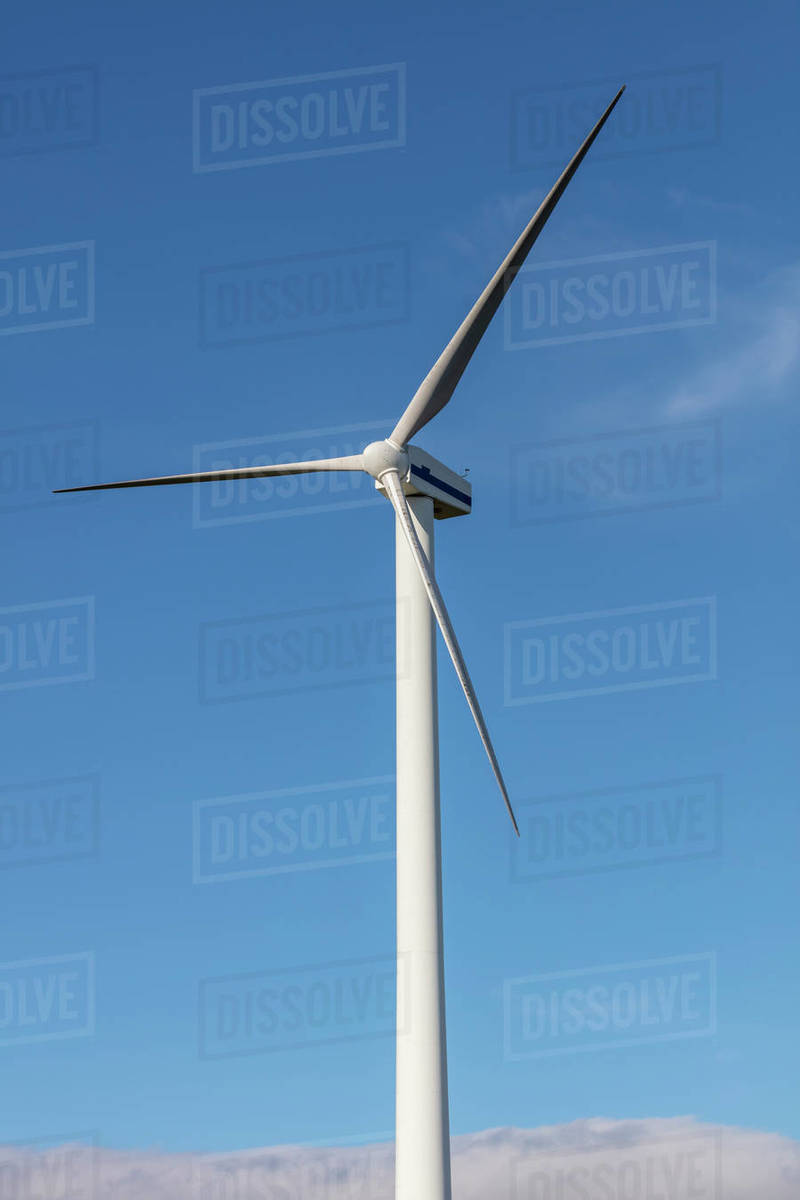 A large three blade industrial wind turbine generating electricity in a ...