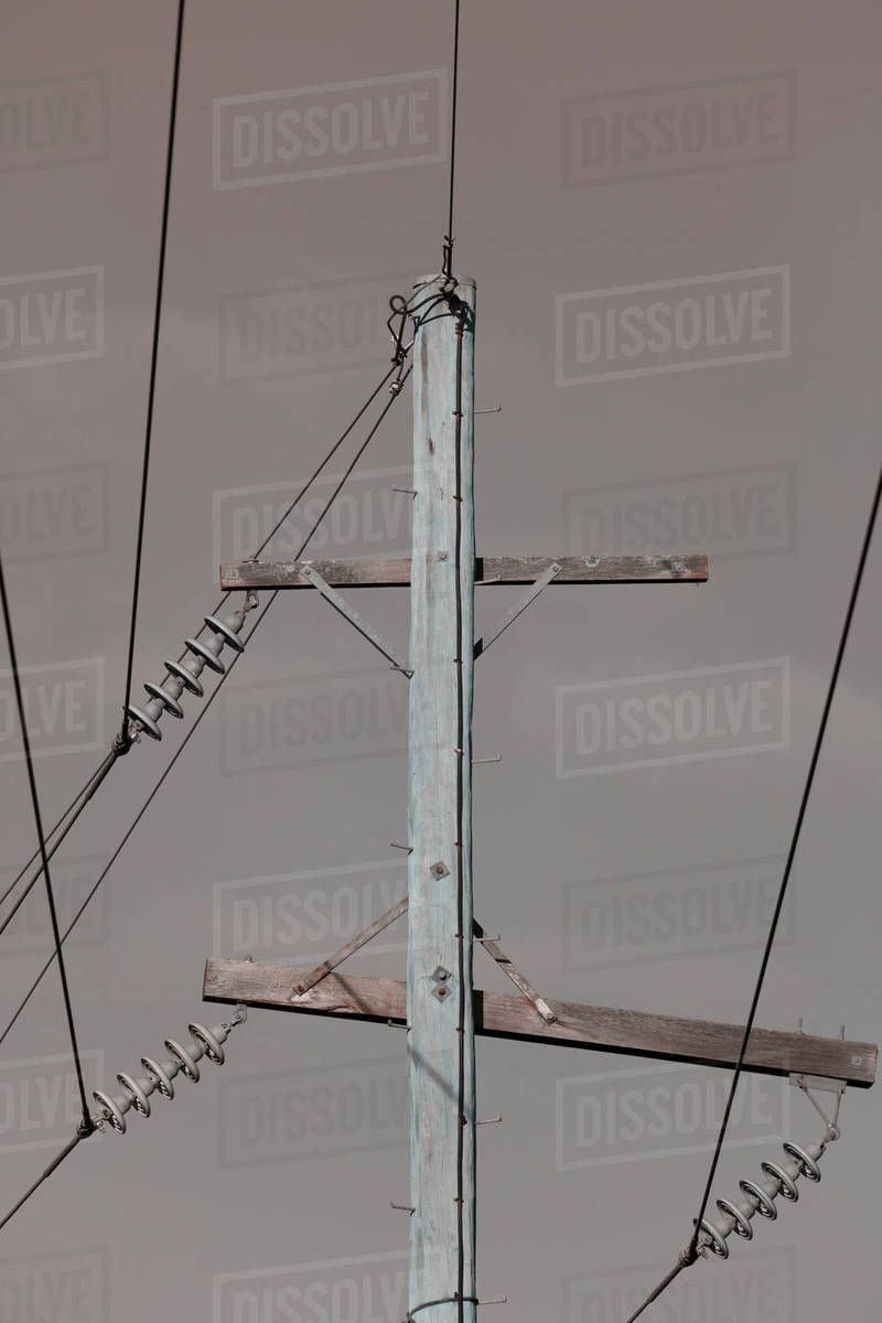 A wooden telephone post and cables against a blue sky - Royalty-free ...