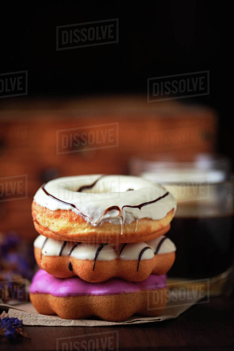 Sweet glazed donuts stacked on a table - Stock Photo - Dissolve
