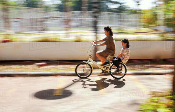 Boy and girl rides the bicycle to fast in a public park - Royalty-free ...