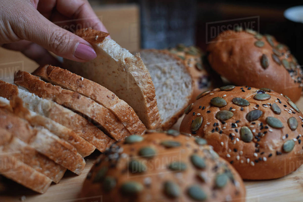 Hand of woman pick a wholewheat bread - Royalty-free Stock Photo | Dissolve