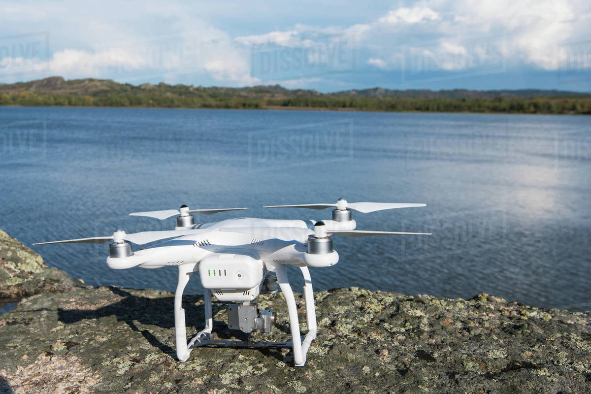 The drone copter with digital camera ready to flying on lake background ...