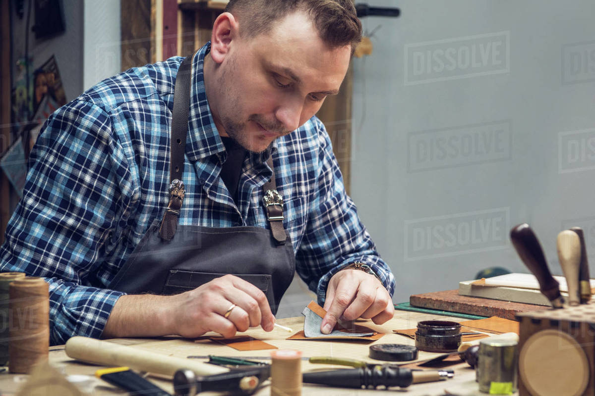 Man working with leather textile at a workshop. Concept of handmade ...