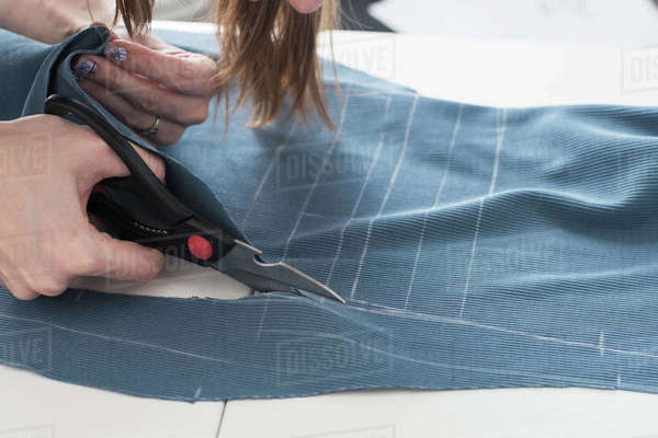 Woman dressmaker cutting fabric textile with scissors - Royalty-free ...