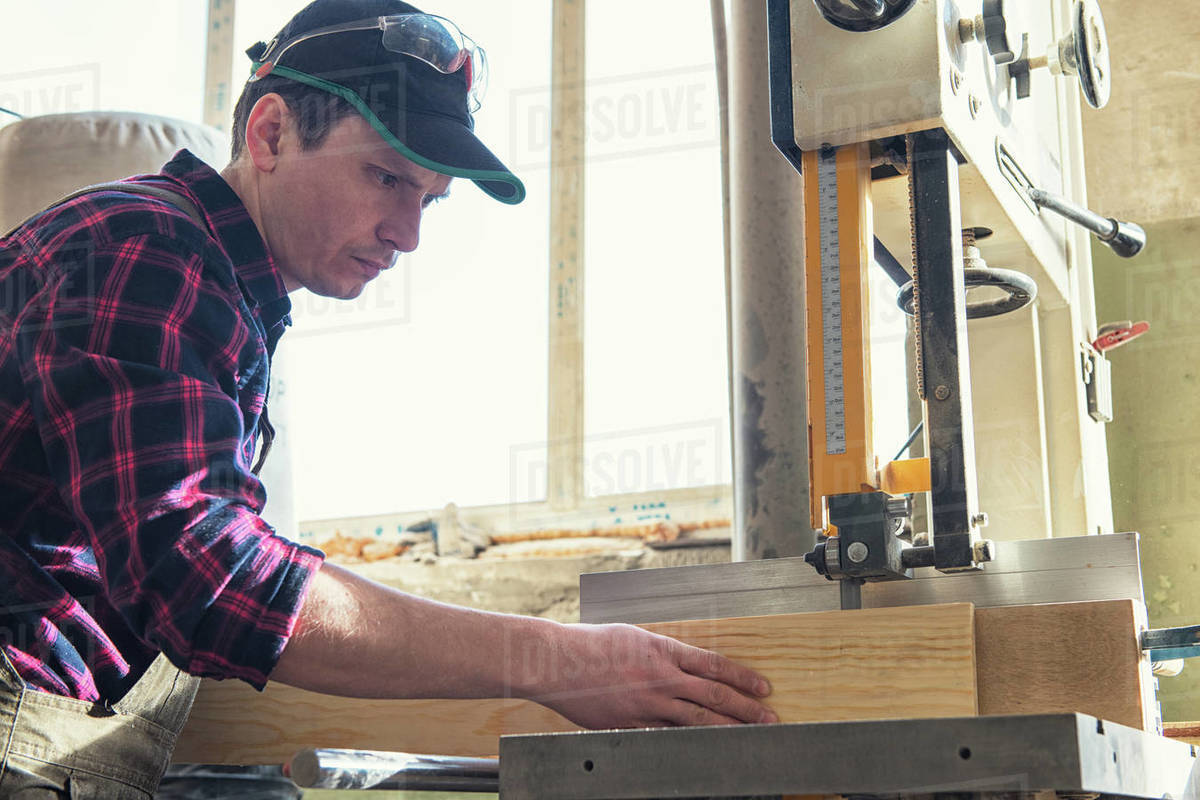 Construction worker cutting wooden board with circular saw - Royalty ...