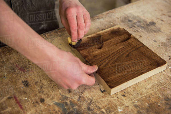 Carpenter painting wooden board in a wooden workshop. Profession ...