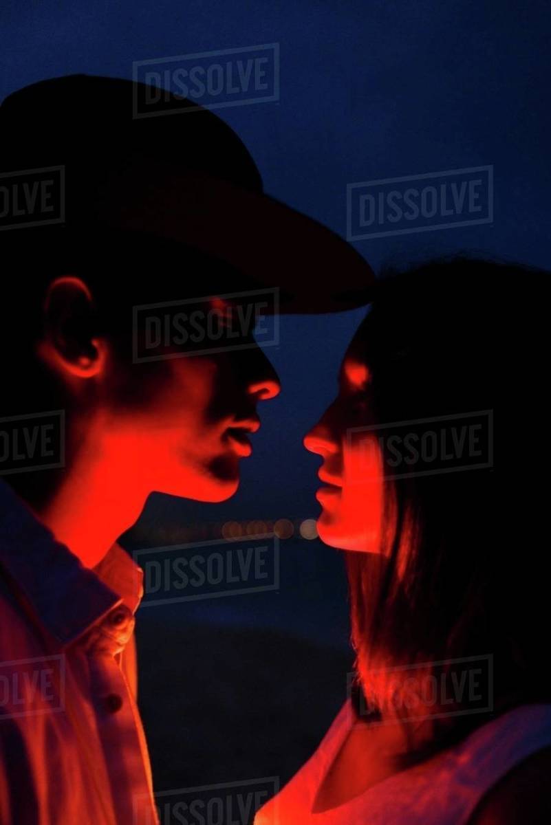 Couple hugging in the dark with neon light - Stock Photo - Dissolve