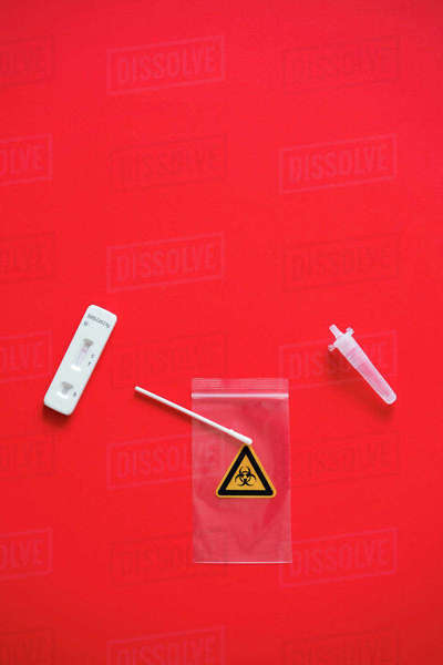 Rapid antigen test kit on the red background - Stock Photo - Dissolve