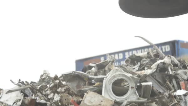 Electromagnet picking up and releasing metal objects at a scrap metal ...