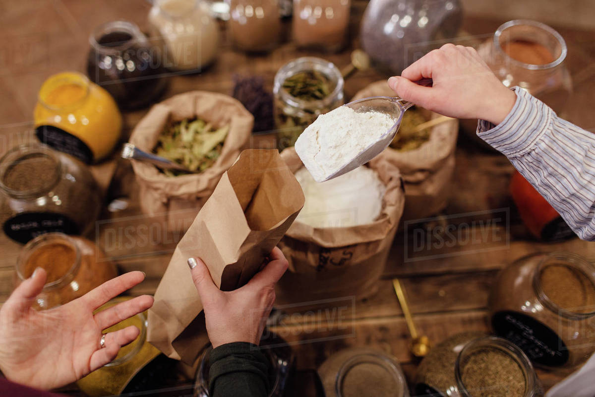 Shop assistant hand only scooping flour for customer in packaging free ...