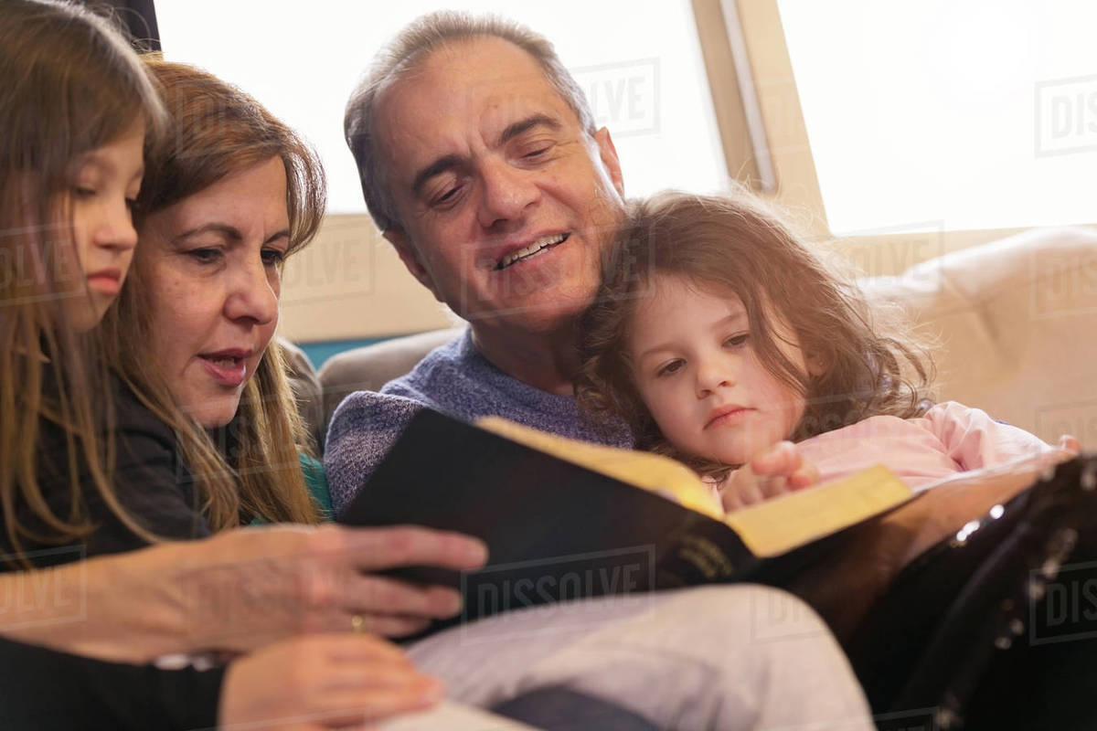 Grandparents teaching grandchildren about the Holy Bible - Royalty-free ...