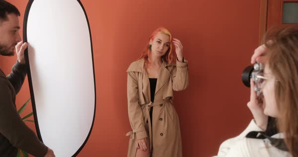 Process of a photo session in the studio, female photographer with male ...