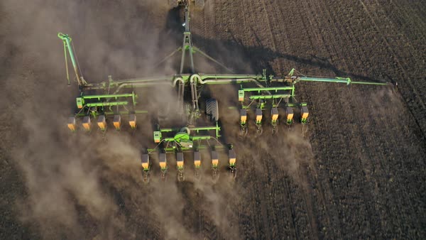 Spring field work, a tractor with a mounted seeder sow seeds in the ...