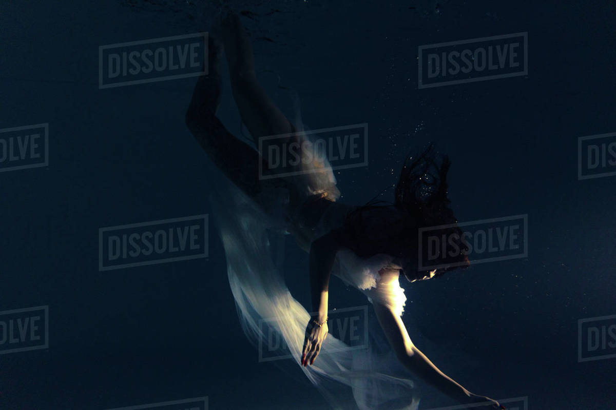 Underwater shoot of beautiful woman in white flying transparent dress ...