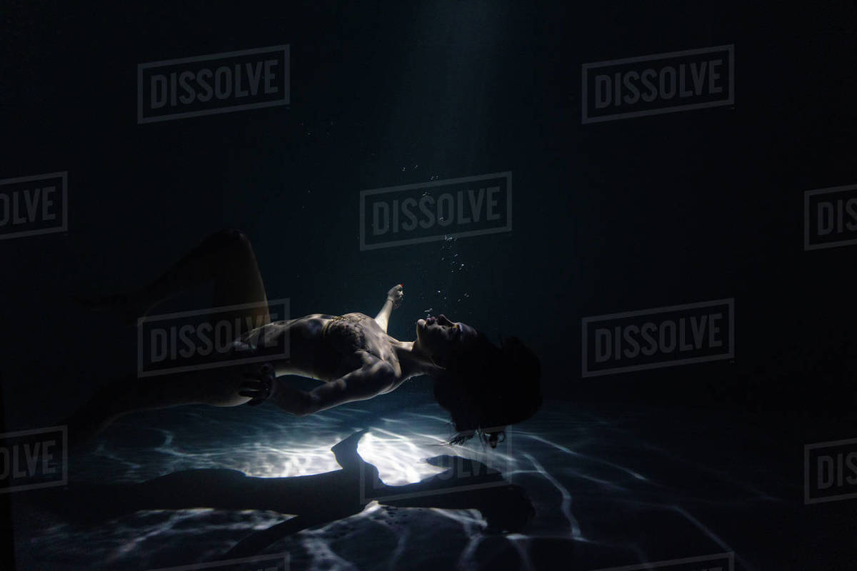 Underwater shoot of beautiful woman swimming and relaxing in water in ...