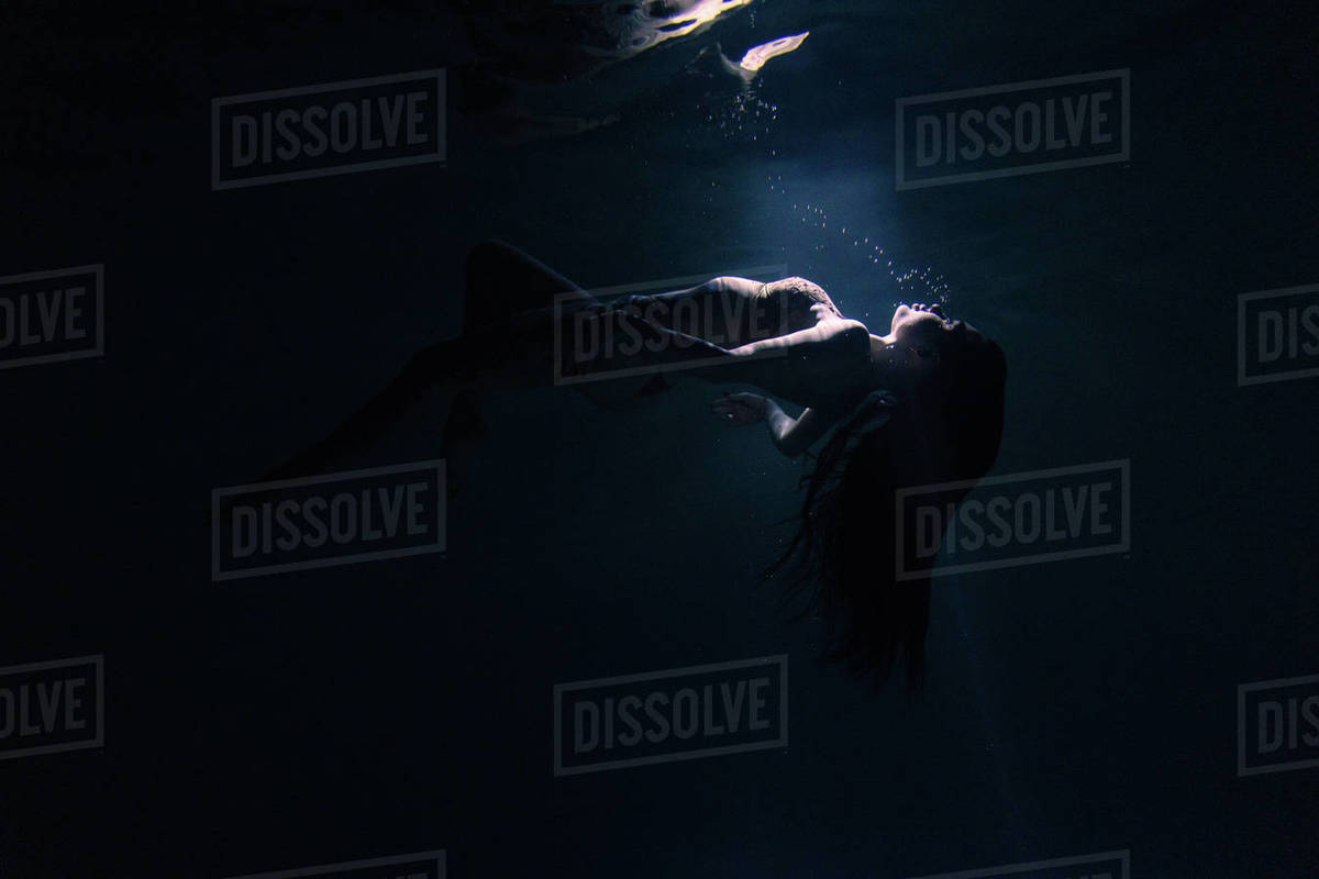 Underwater shoot of beautiful woman swimming and relaxing in water in ...
