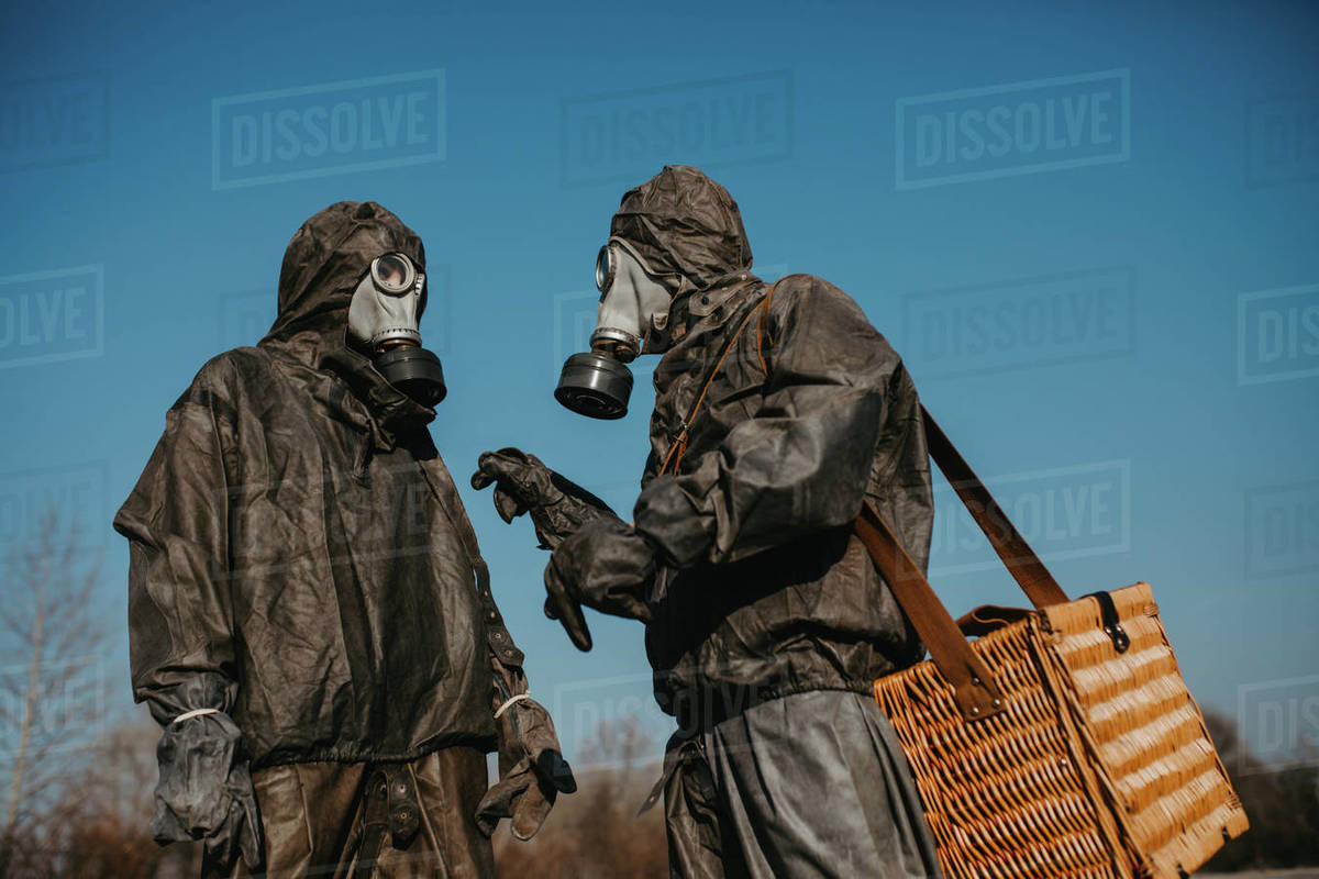Couple in love walks in protective suits and gas masks. Concept of a ...