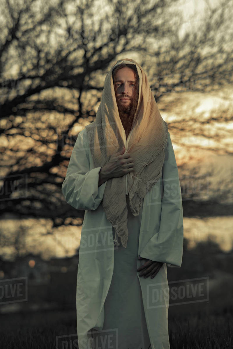 Prophet walks in meadow clothed in his traditional white robe against ...