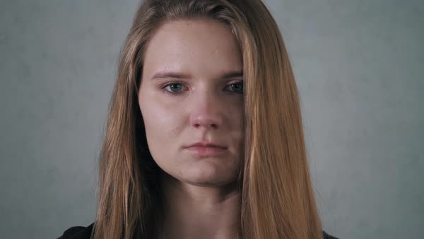 Young woman crying looking at the camera. Tears comes out of an eyes ...