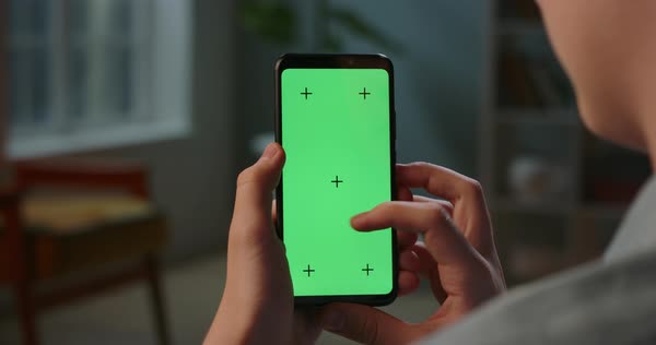 Close up shot of guy using his smart phone with mock up green screen at ...