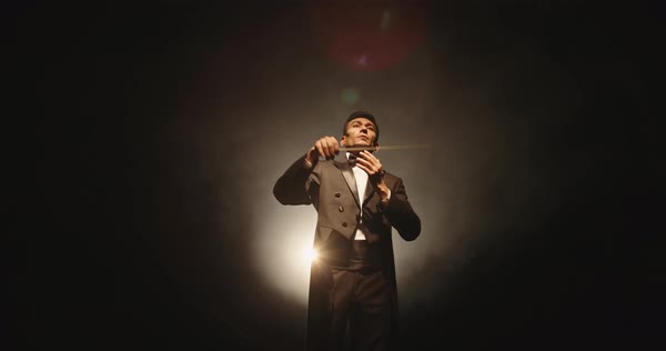 Asian male orchesra conductor wearing tux is directing symphony ...