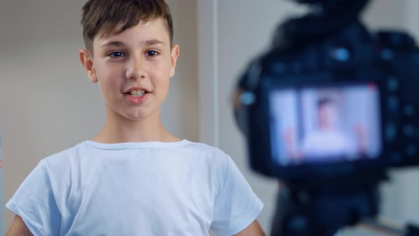 Boy videoblogger filming new vlog video with professional camera at ...