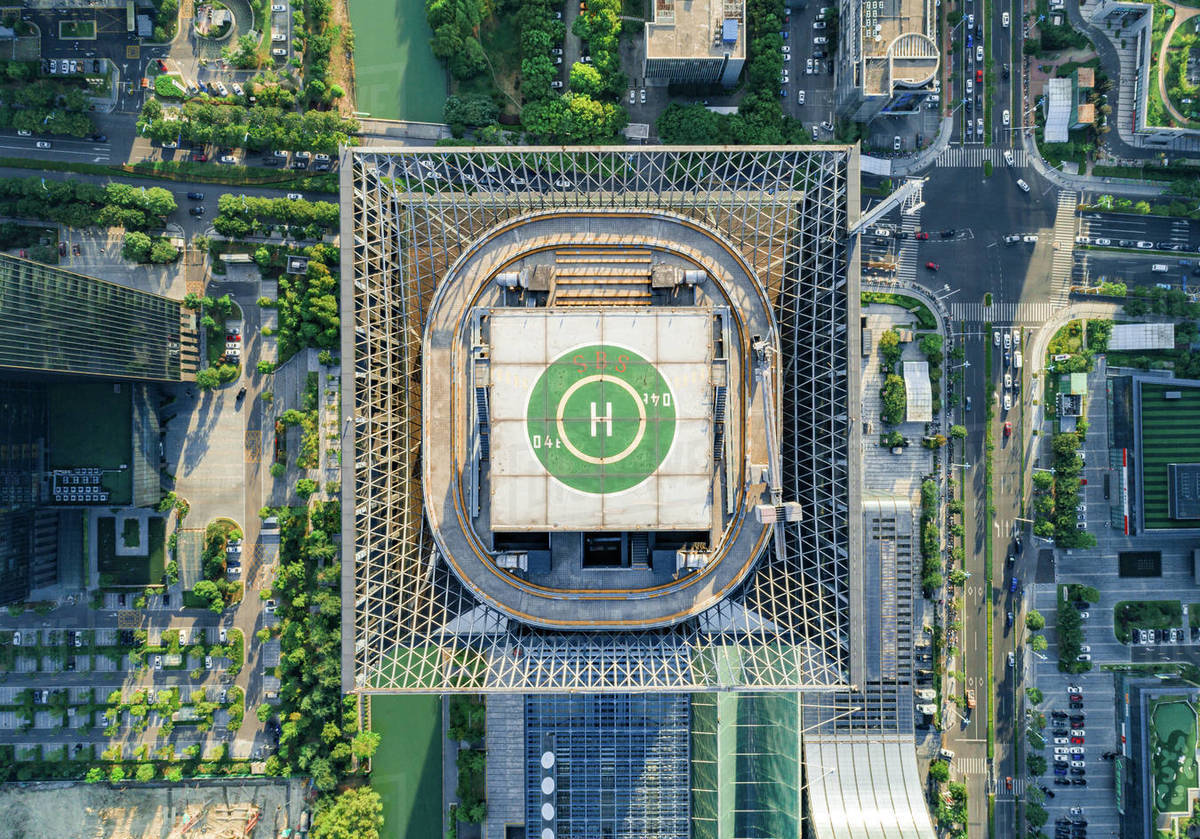 Aerial drone view of helipad on the roof of a skyscraper in downtown ...