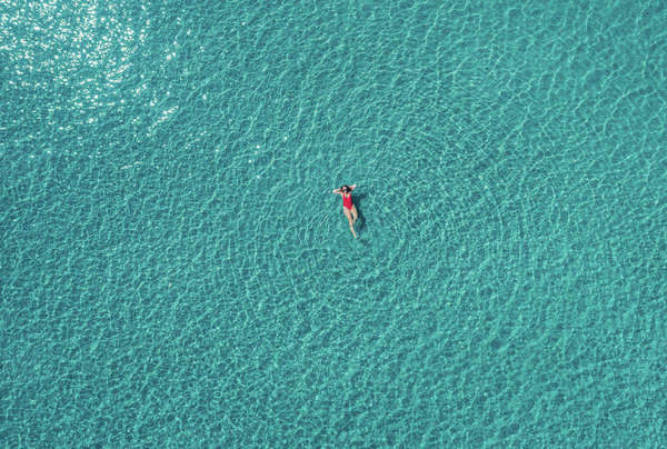 Aerial View of a Woman in Red Swimsuit Floating Serenely on the Crystal ...