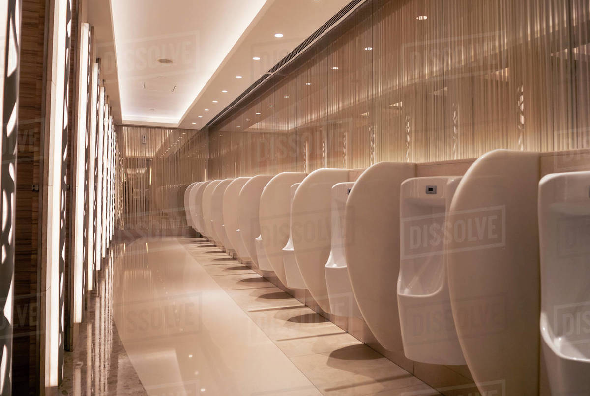 Modern public restroom with sleek white urinals and elegant lighting at ...