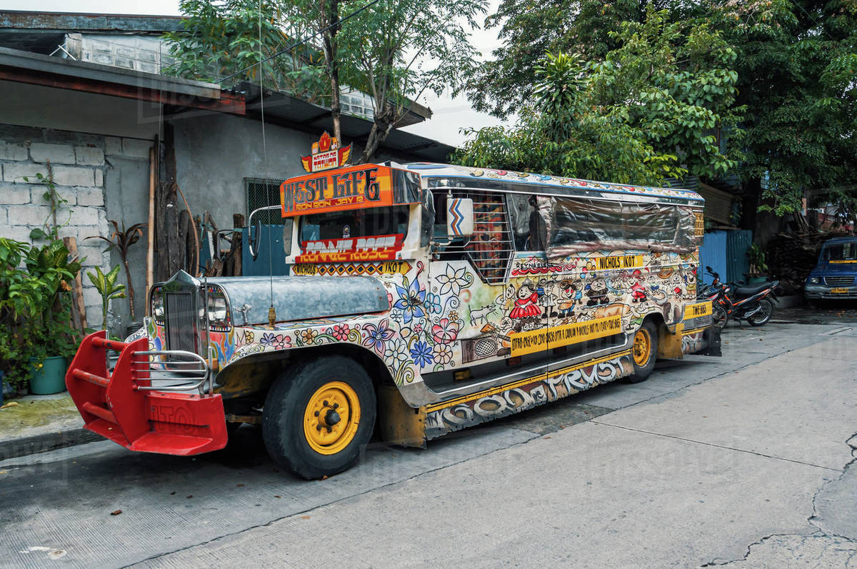 A brightly colored jeepney, a popular form of public transportation in ...
