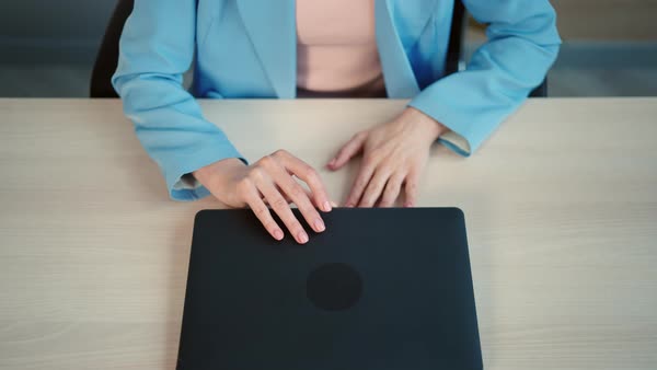 Close up woman sitting at a desk turn on laptop typing on keyboard ...
