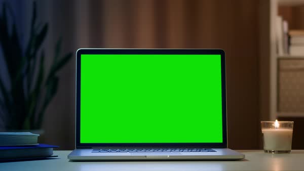 Modern laptop with mock up chroma key green screen on desk of living ...