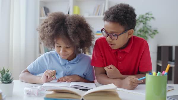 Brother explaining math problem to his little sister, siblings studying ...