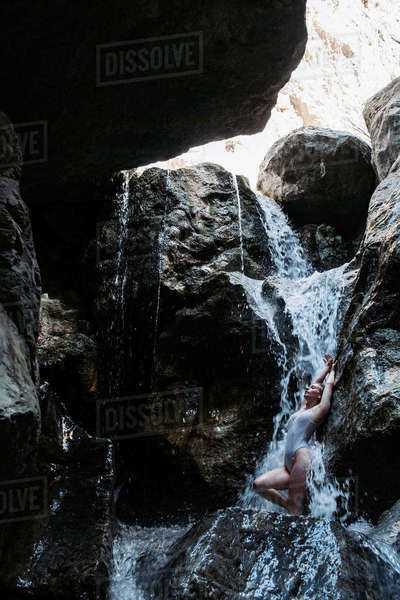 Vertical shot of an attractive sexy woman in a swimsuit posing under a ...