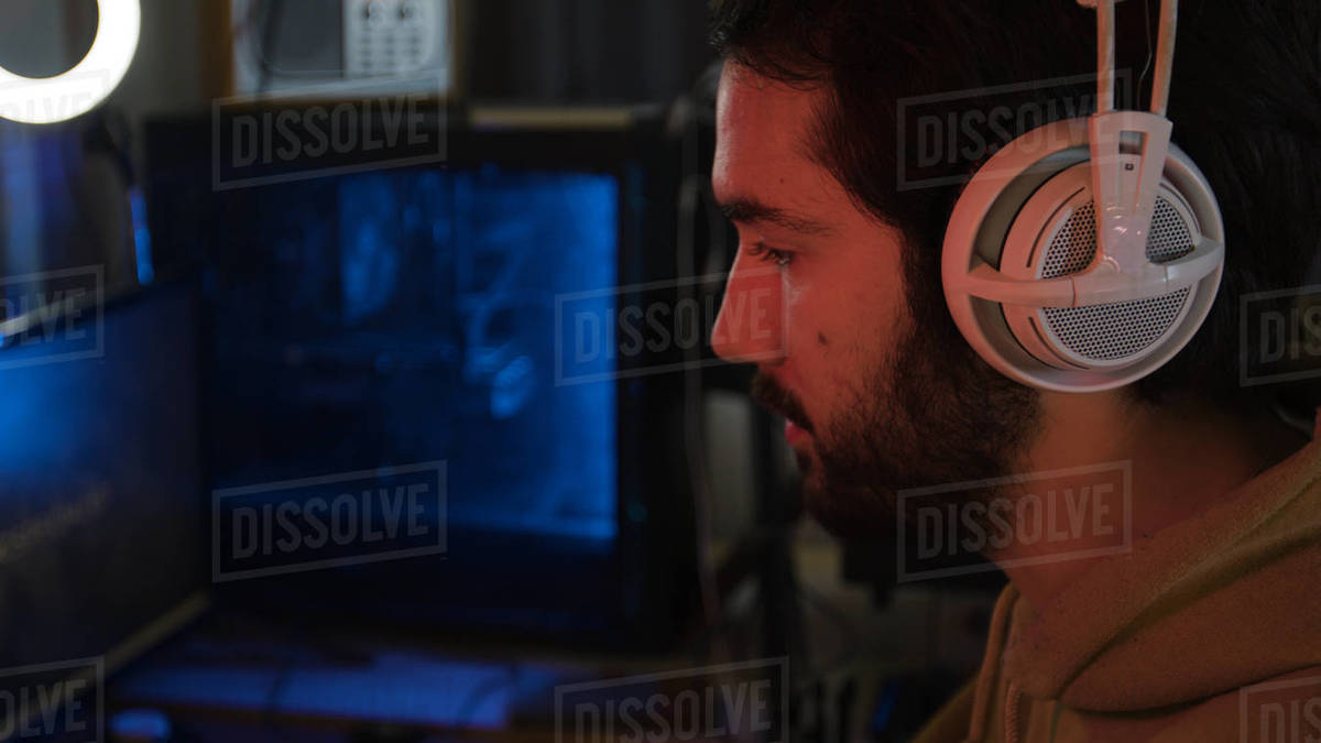 Male gaming on a pc streaming over the shoulder white headphones blue ...
