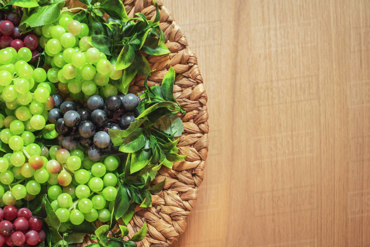 Grapes on a wooden plate. - Royalty-free Stock Photo | Dissolve