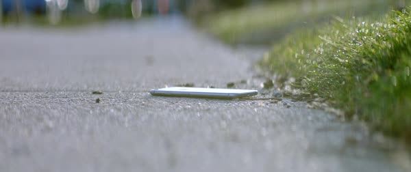Medium shot of a smartphone falling on street - Stock Video Footage ...