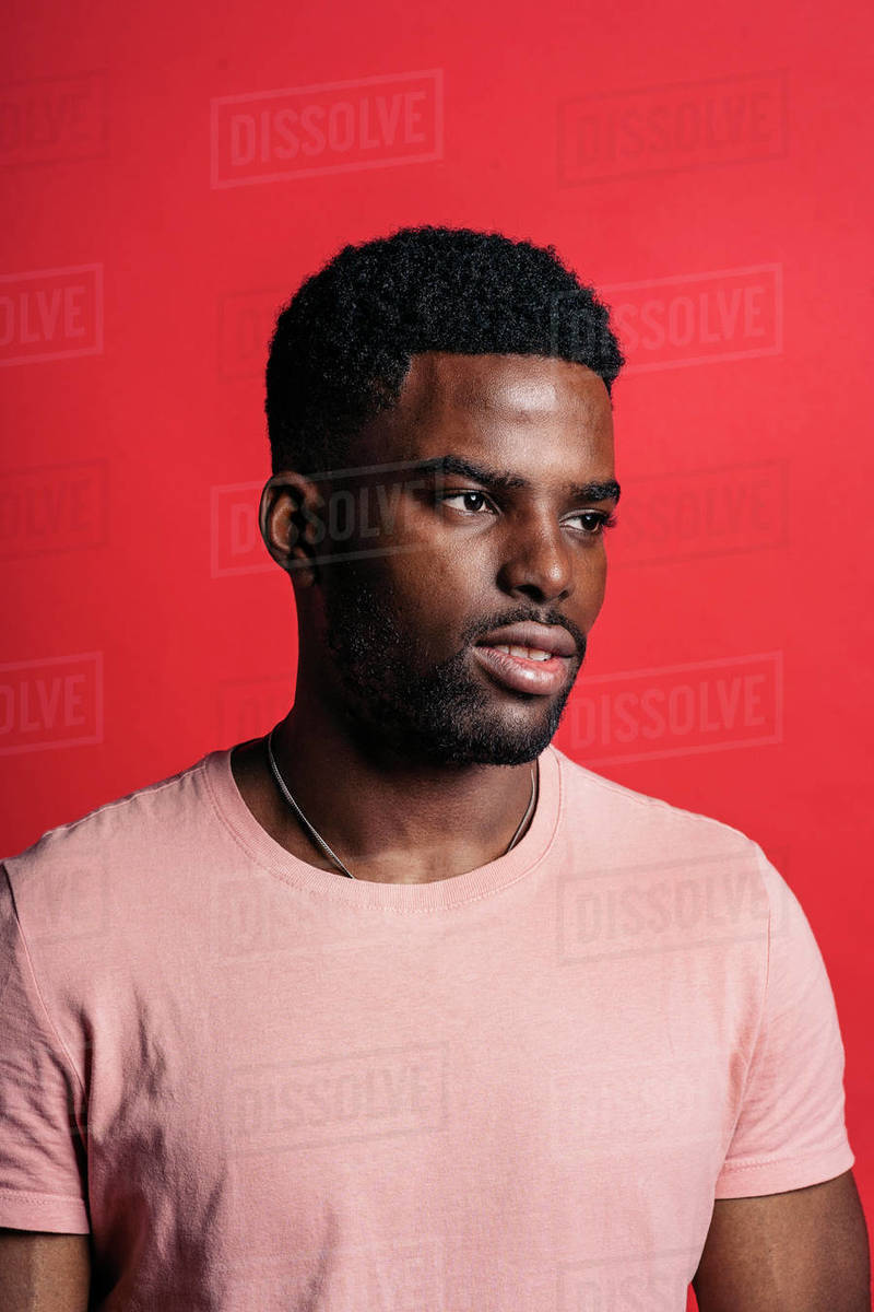 Portrait of young african man on bright red background - Royalty-free ...